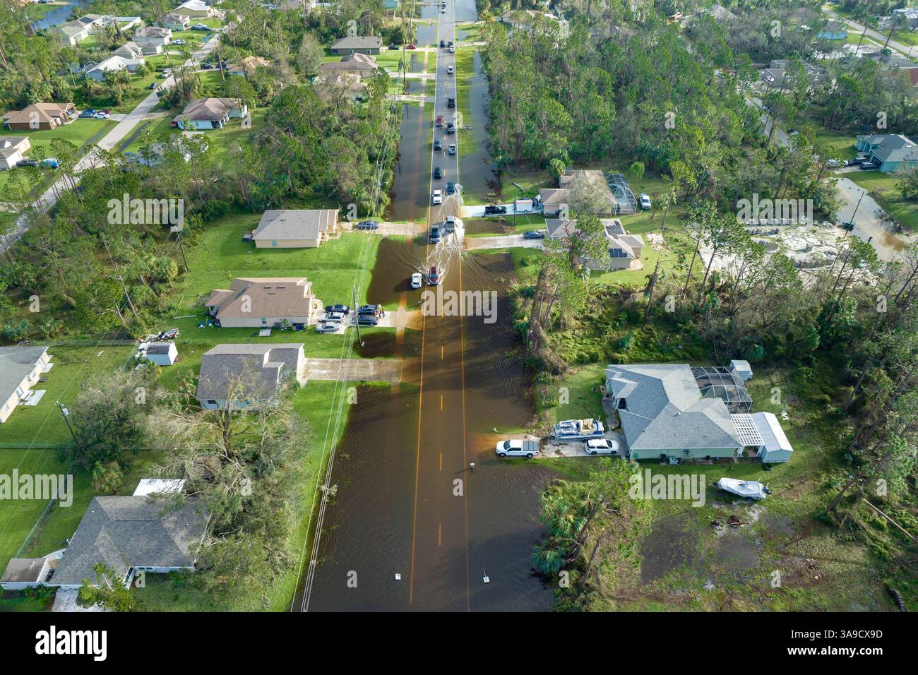 Flooded Florida road with evacuating cars and surrounded with water ...