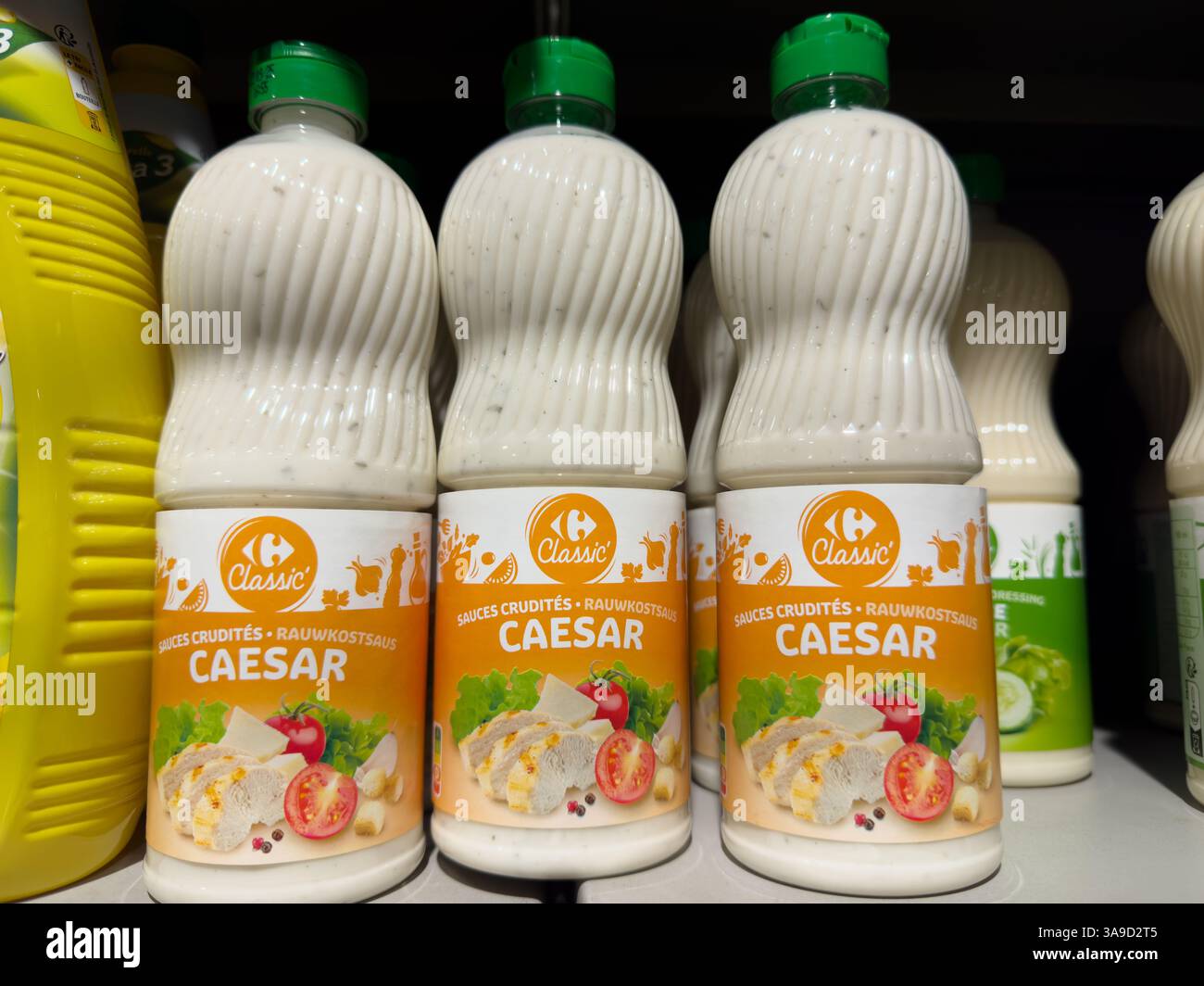 Bottles of creamy Caesar dressing lined up on a store shelf waiting to ...