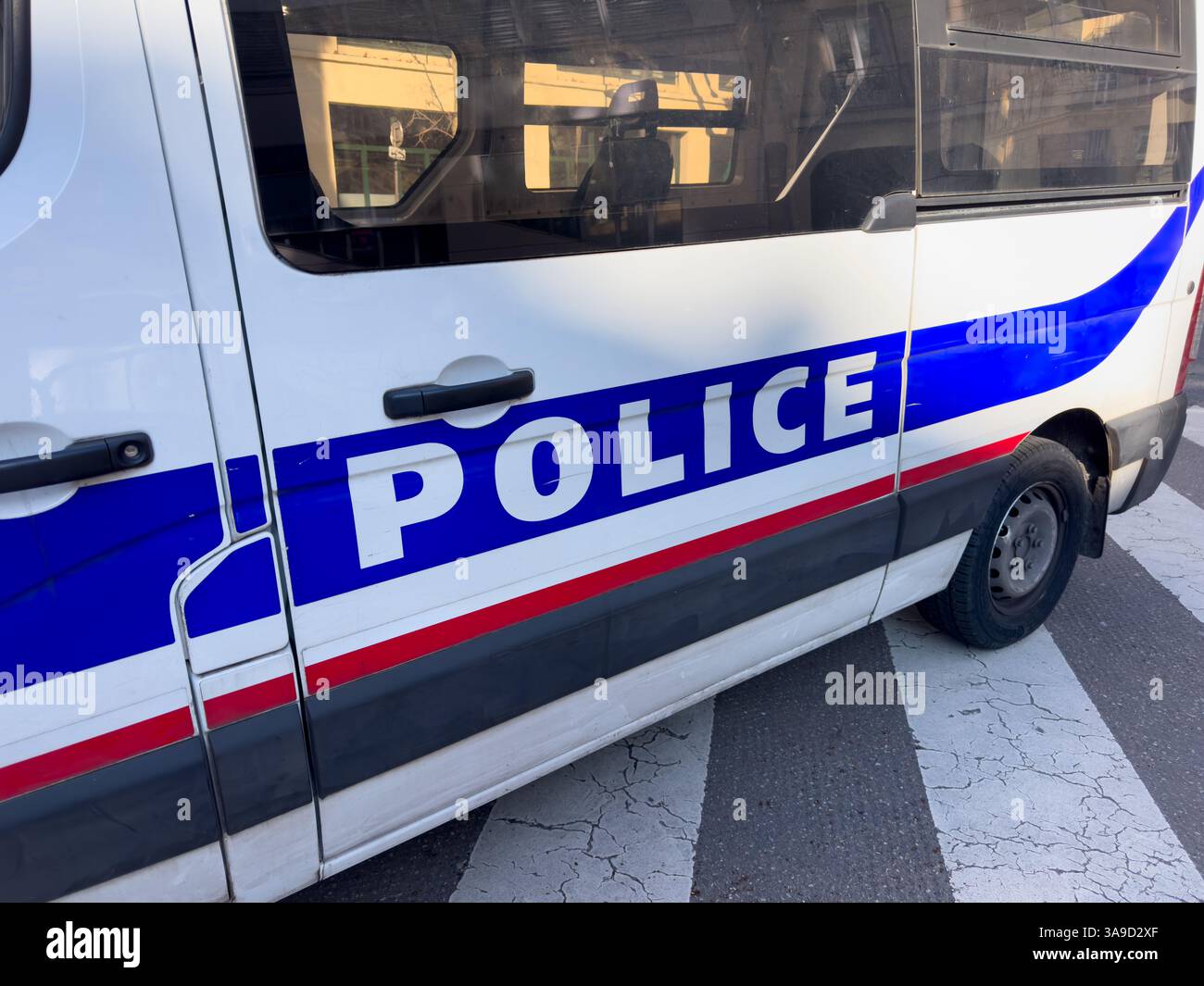 Police vehicle parked on a busy street in the evening light reflecting ...