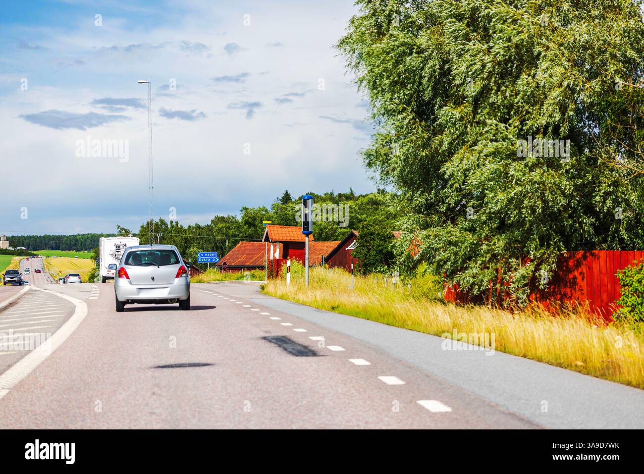 Speed control camera installed on countryside road with cars driving ...