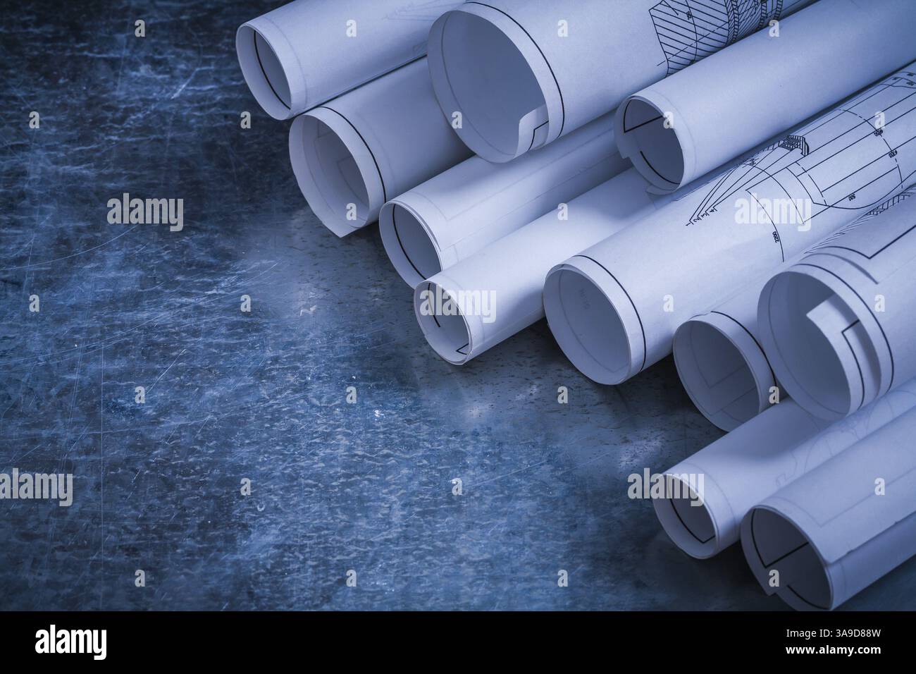 Rolled engineering drawings on scratched vintage metallic background ...