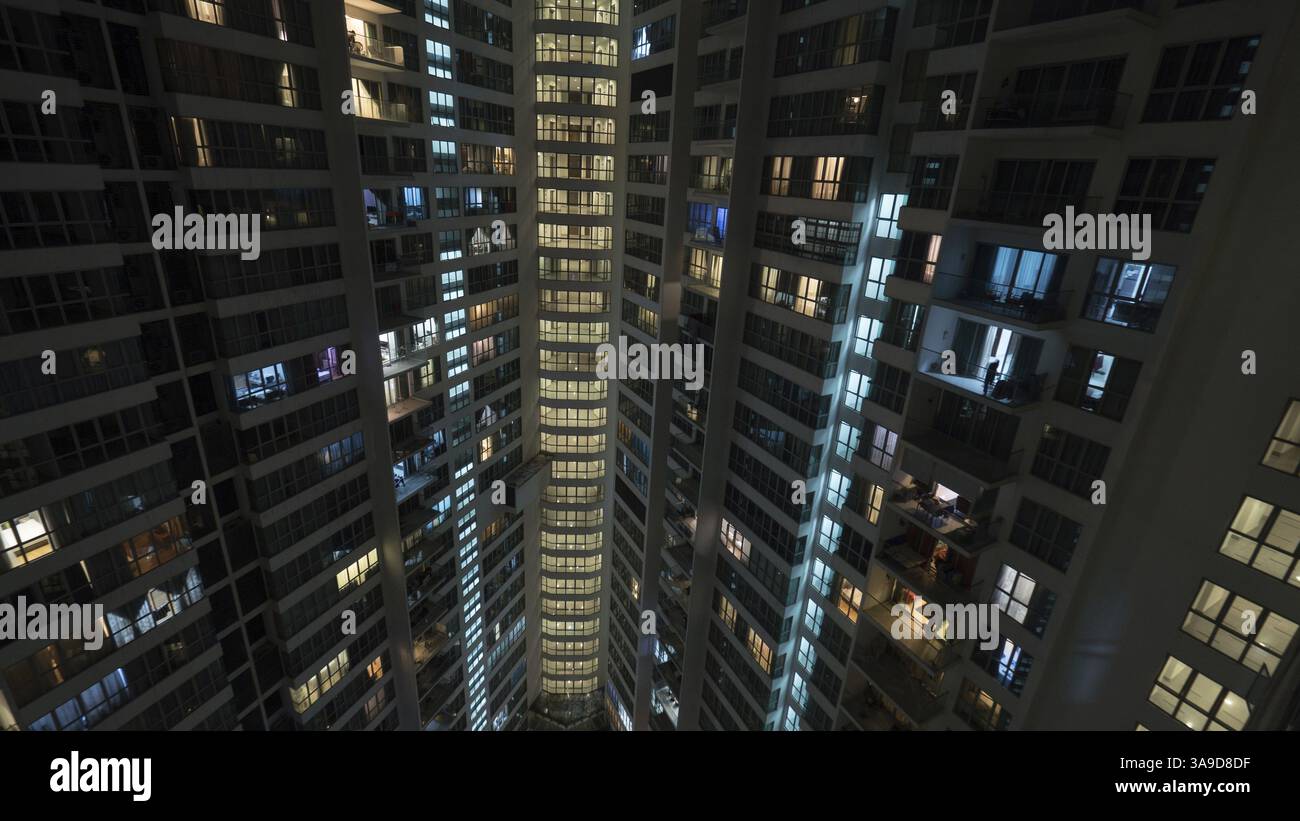 Lights in the windows of high-rise apartment block at night. Kuala ...