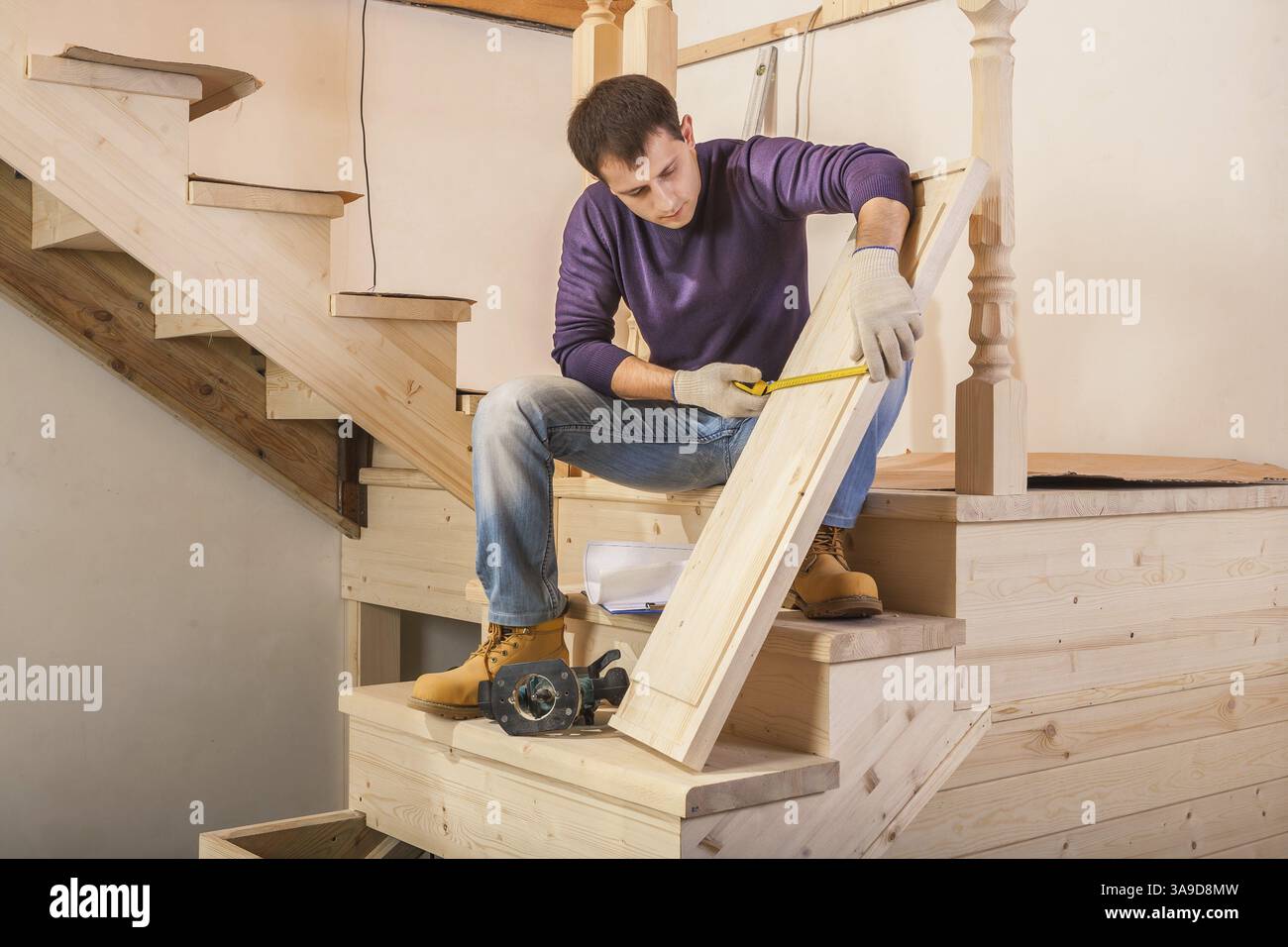 Carpenter measuring step of ladder Stock Photo - Alamy