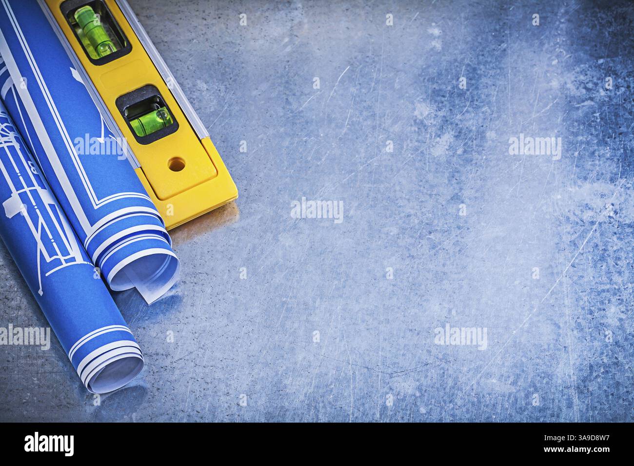 Rolled up construction drawings level on metallic background Stock ...
