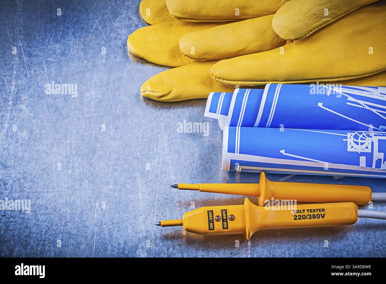 Yellow electrical tester protective gloves blue engineering drawings on ...