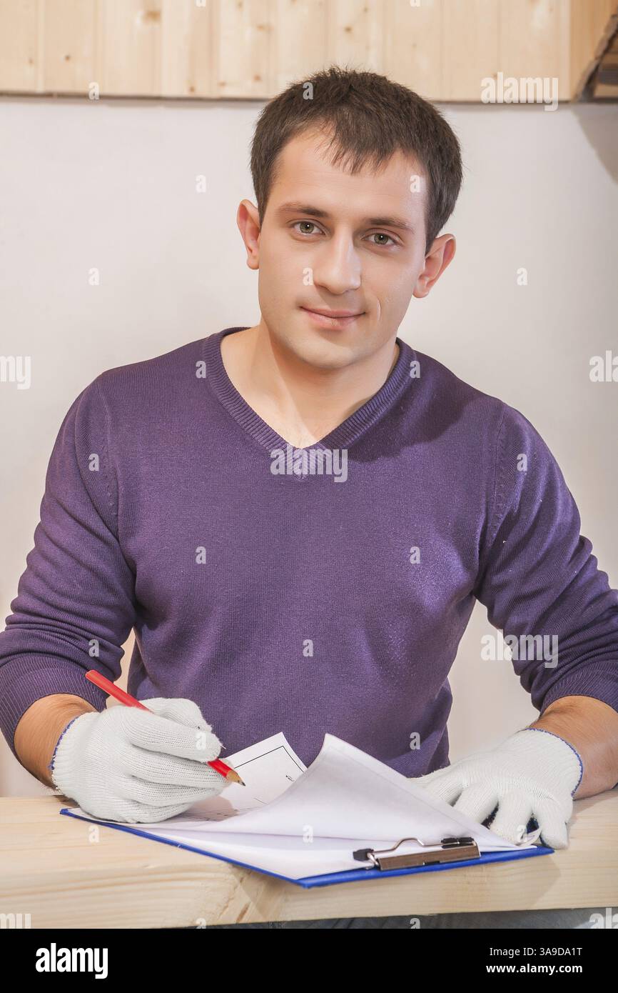Contractor with pencil drawing in blueprint Stock Photo - Alamy