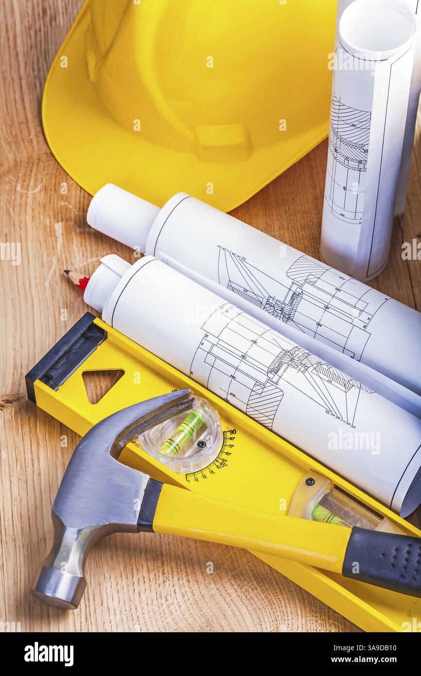 Yellow helmet rolled blueprints hammer level on wooden board Stock ...