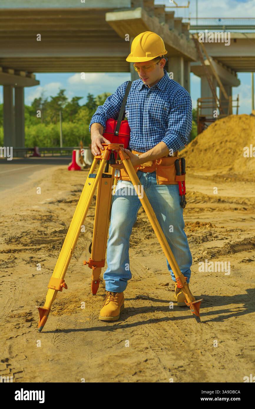 Construction worker adjusting theodolite Stock Photo - Alamy