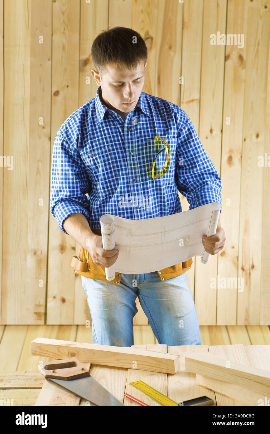 Carpenter looks on blueprint Stock Photo - Alamy