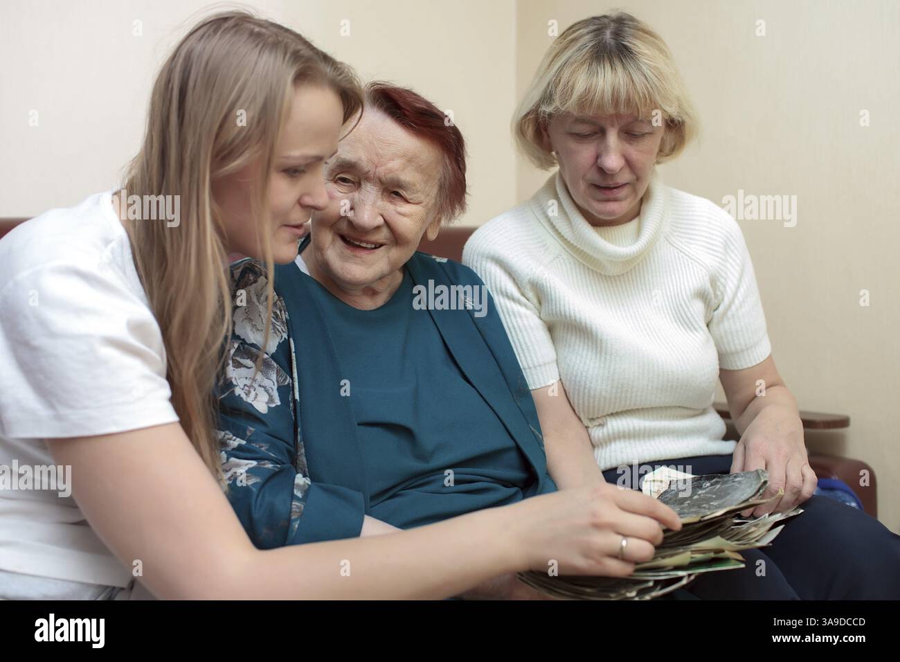 Grandmother, mom and daughter happily bonding over old pictures Stock ...