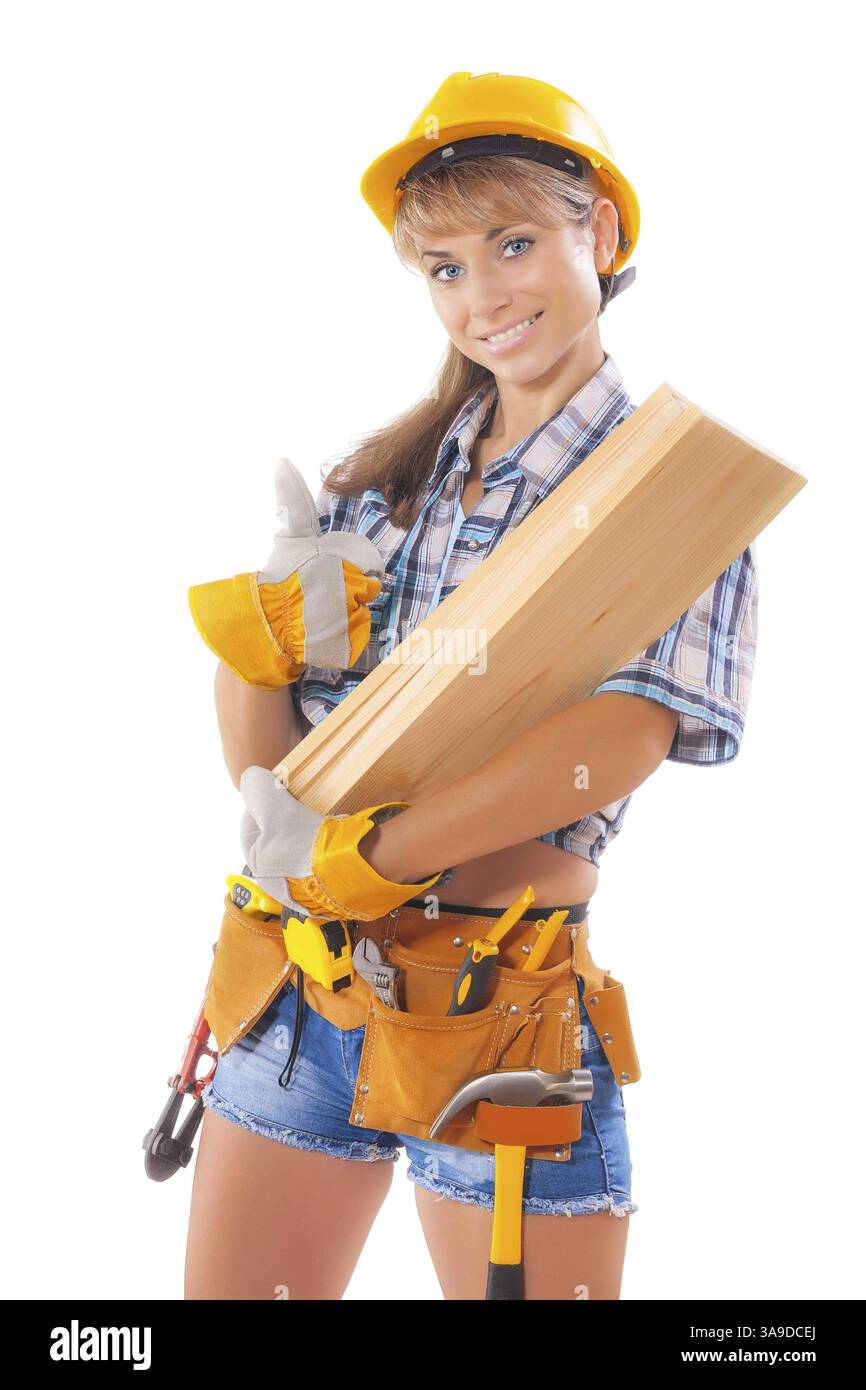 Portrait of young female construction worker carrying wooden boards on arm against white ...