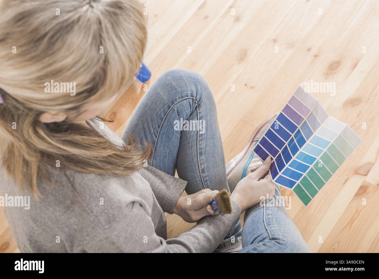 View from top female sitting on floor with color palette selecting color for wall Stock Photo ...