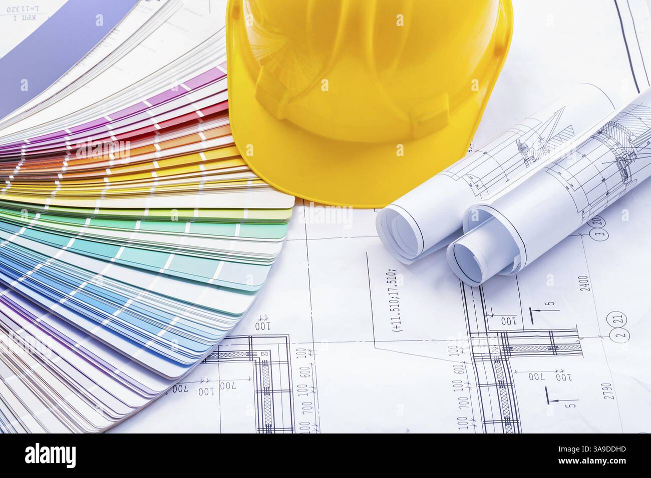 Yellow helmet color palette rolled blueprints Stock Photo - Alamy