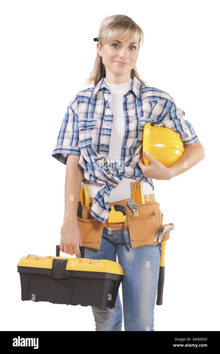 Female wearing working clothes with toolbelt holding hardhat and ...