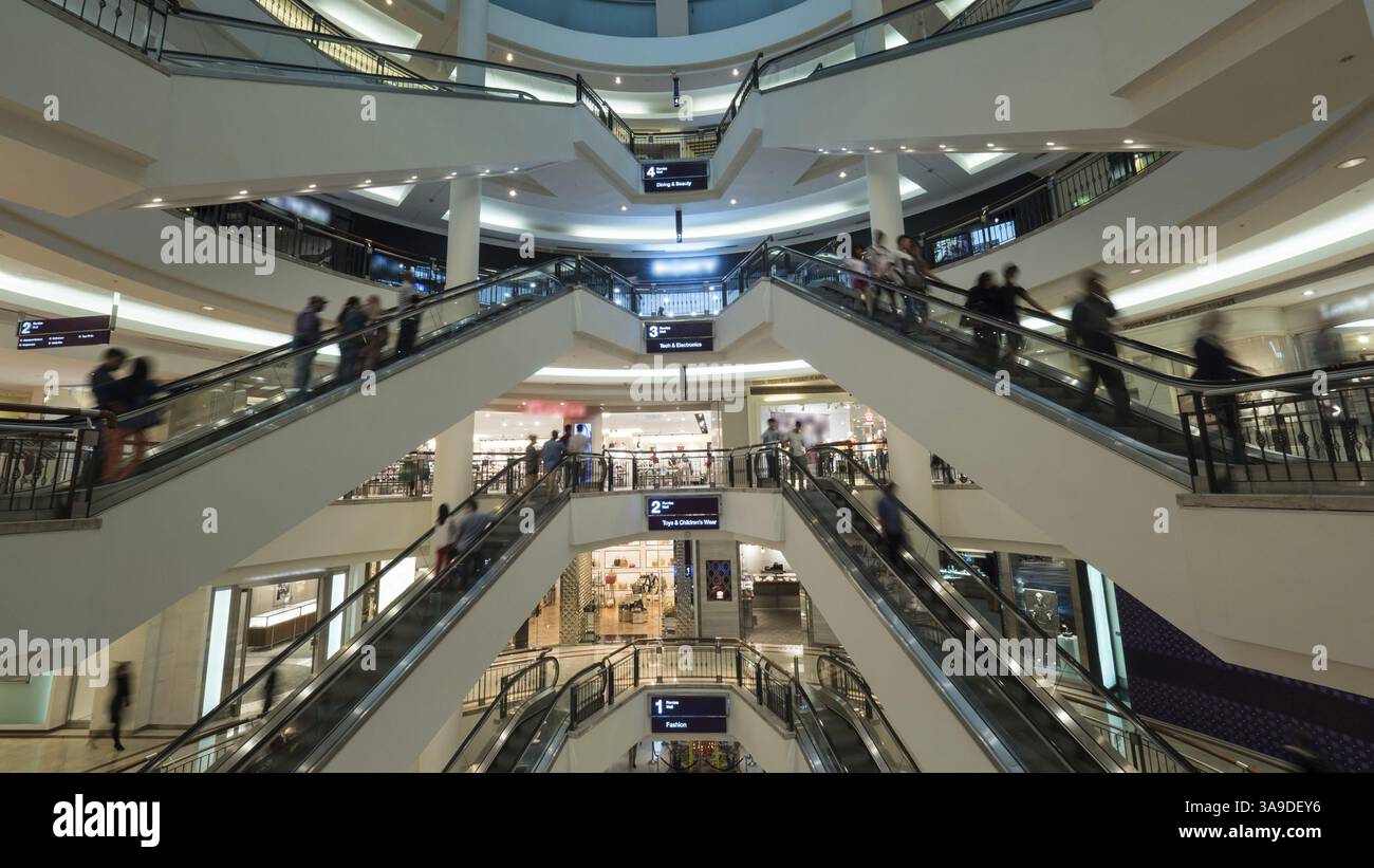 Big light multistorey shopping mall. Customers using escalators to get ...