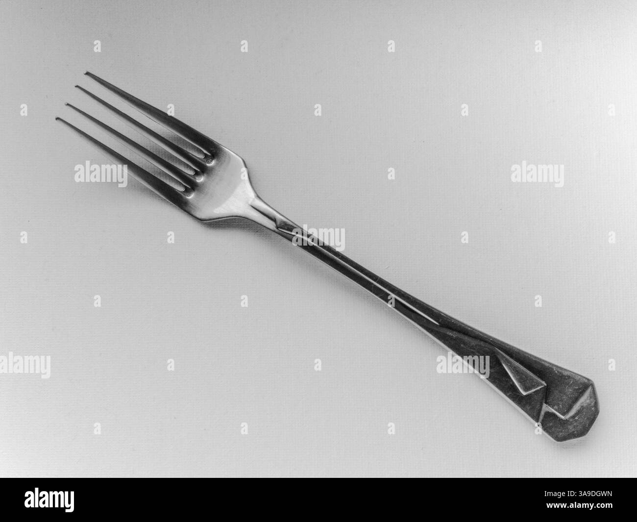 The fork is silver and has a black handle. The fork is bent at the top ...