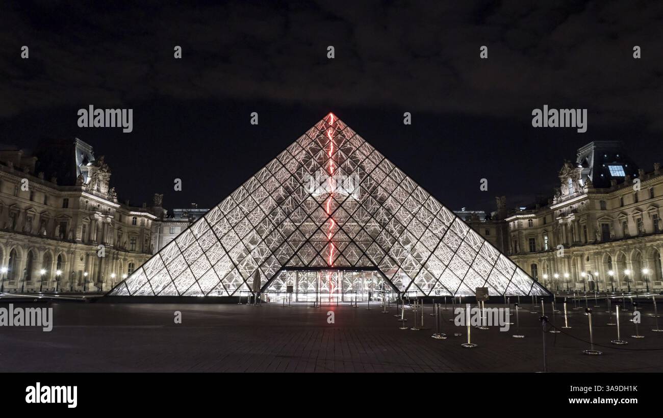 Illuminated glass pyramid at the Louvre, Paris at night in a ...