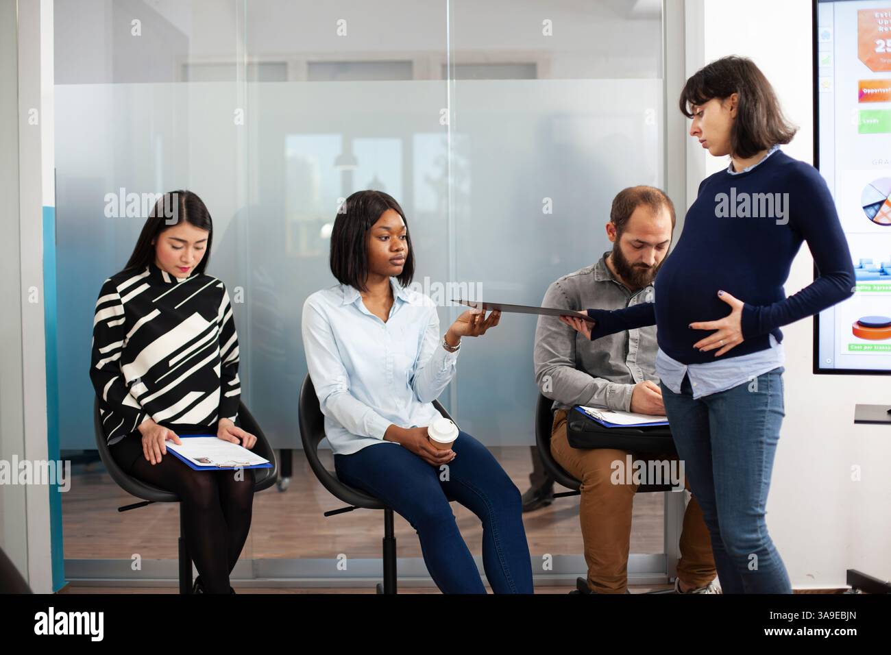 Diverse job applicants seated in lobby area as black woman gives her cv ...