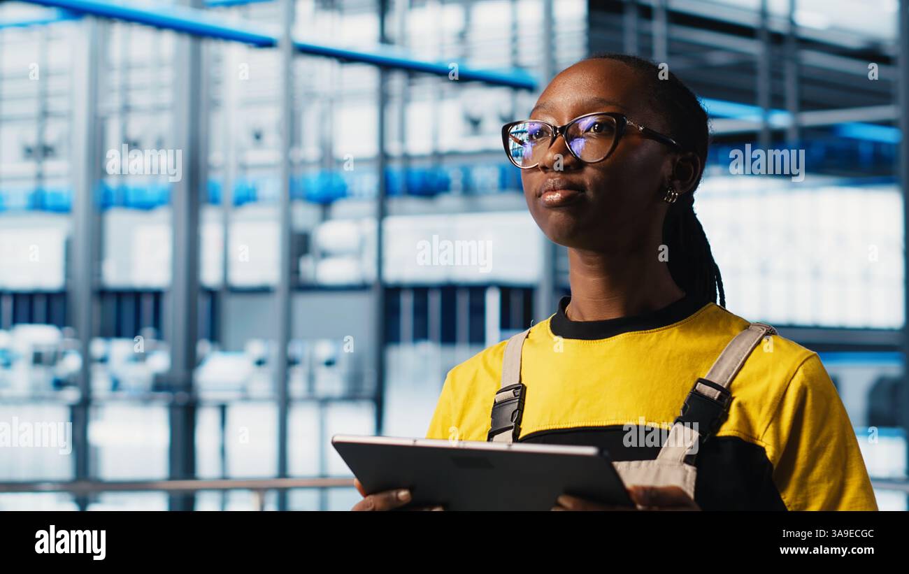 Industry 4.0 plant technician monitors system performance using digital ...