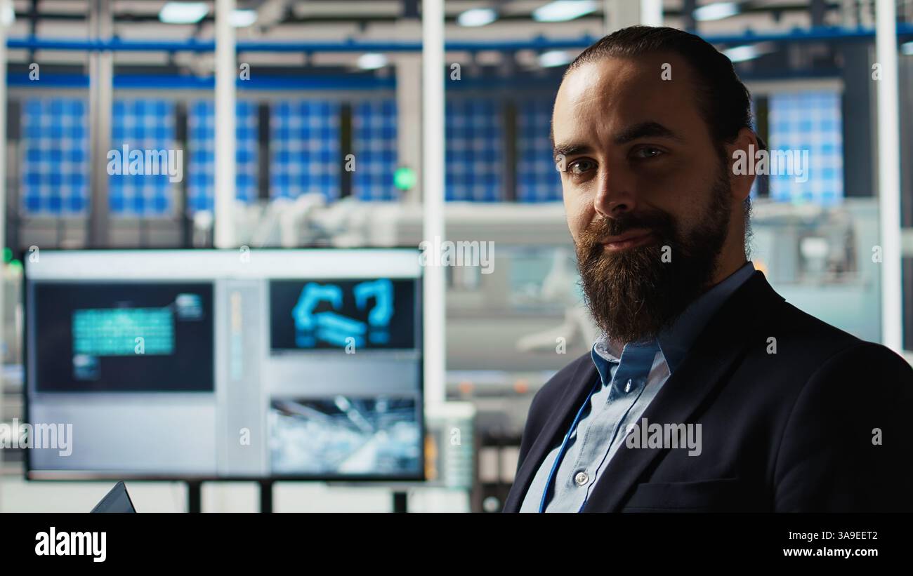Portrait of man in solar panels plant using laptop to improve solar ...