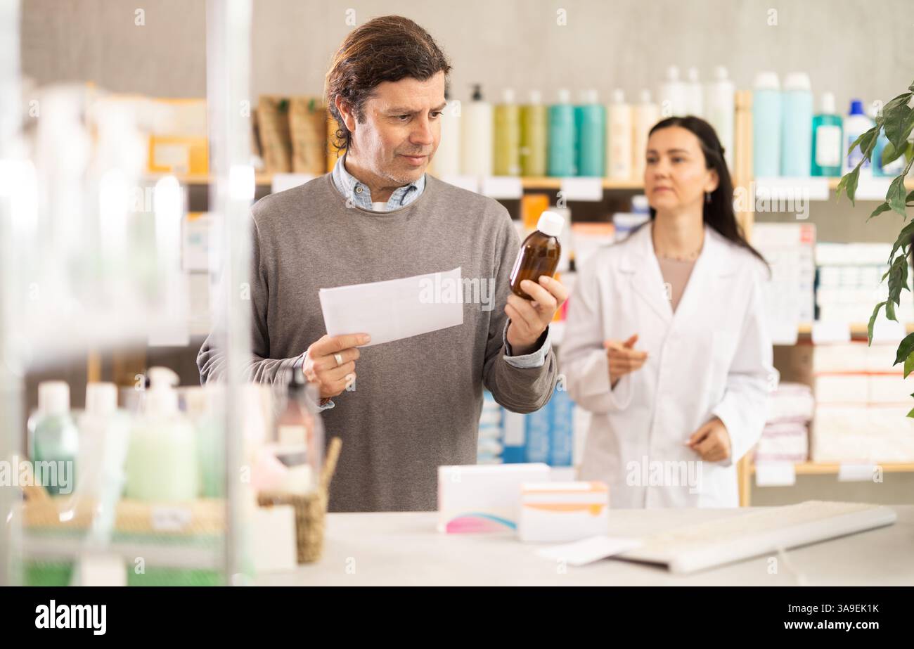 Man buyer scans syrup qr code with woman pharmacist Stock Photo - Alamy