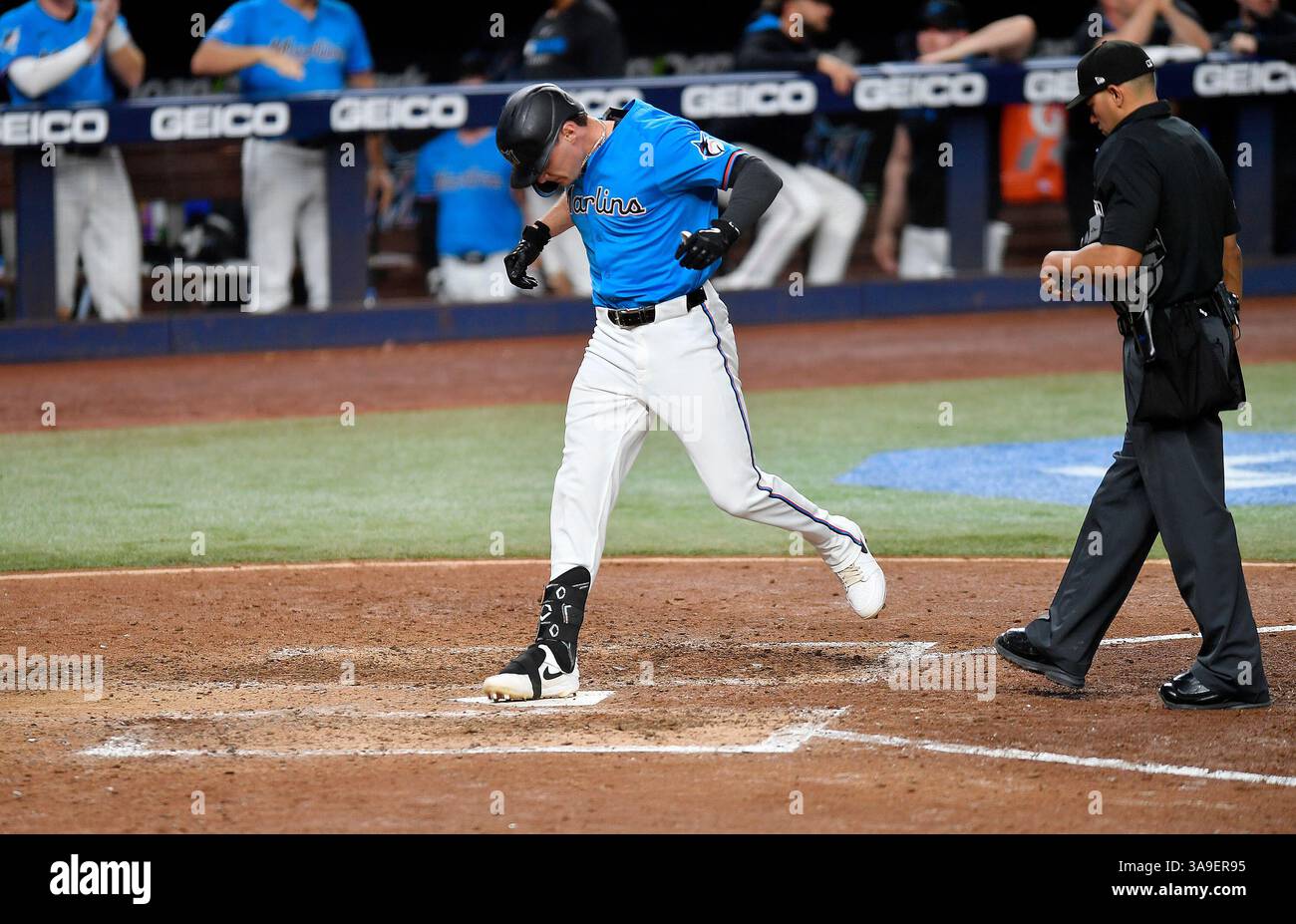Miami Marlins' Griffin Conine ,left, scores during the eighth inning of ...
