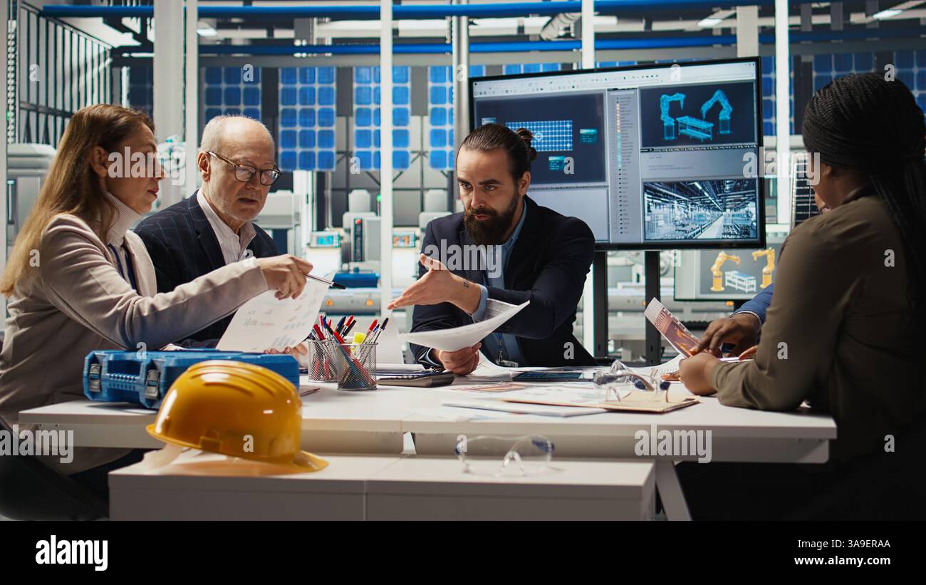 Engineers study detailed schematics of solar panel assembly lines, refining production layouts ...