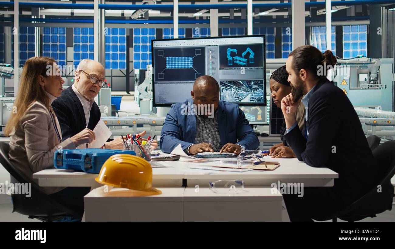 Factory engineering team look at assembly lines designs, working to ...