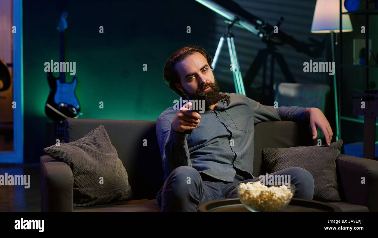 Man using remote to switch channels on television screen, feeling ...