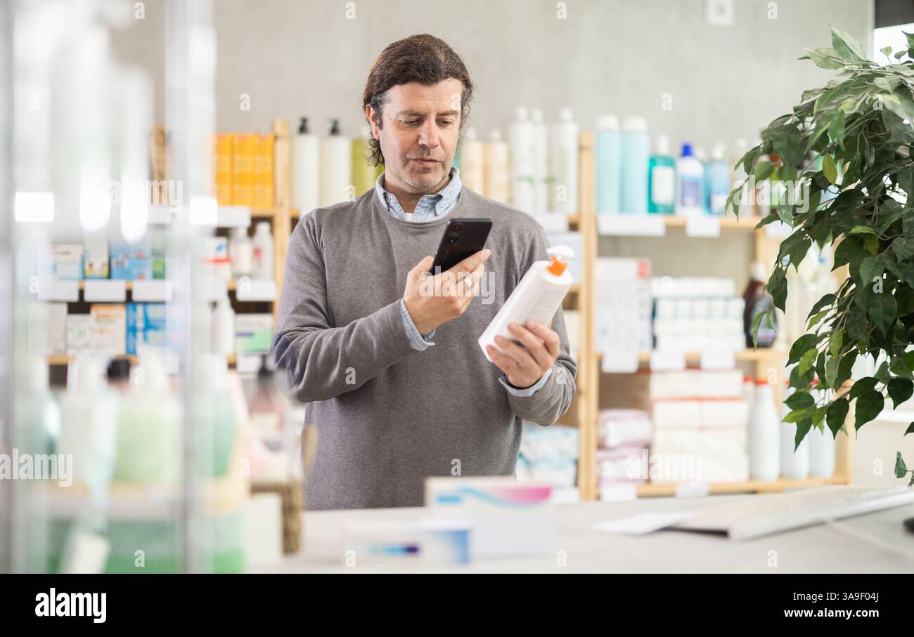 Man in pharmacy scans QR code on emollient cream product Stock Photo ...