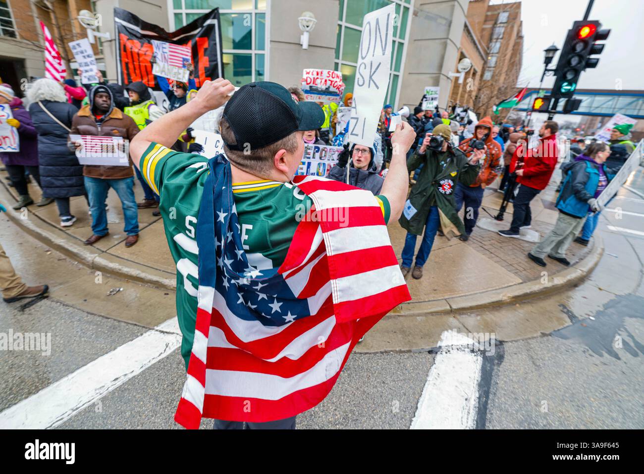 Protesters yell at a man with an American flag as people begin to ...