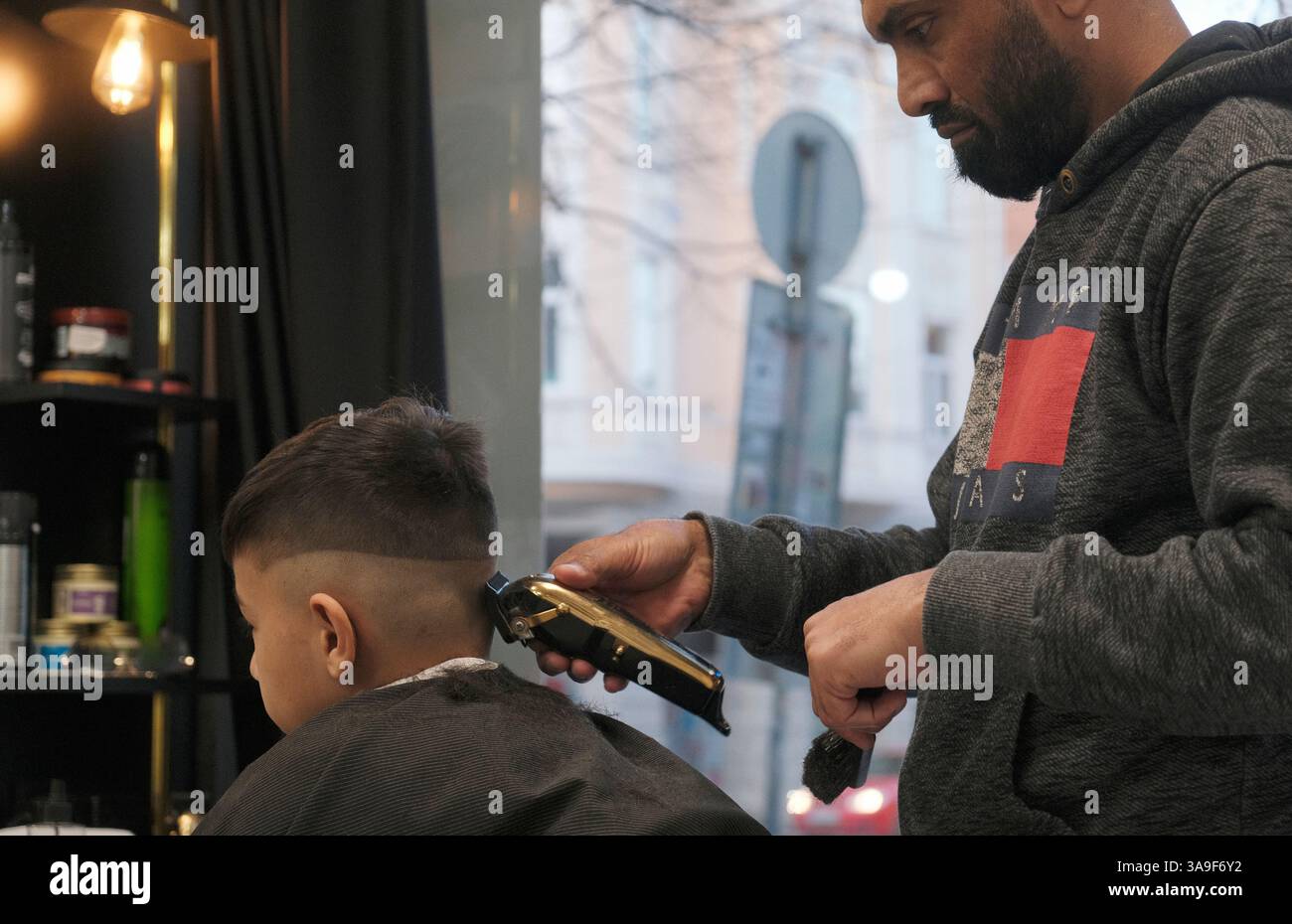 Bulgaria, Sofia; 9 March 2025, bulgarian kid having his hair cut in a local barber shop ...