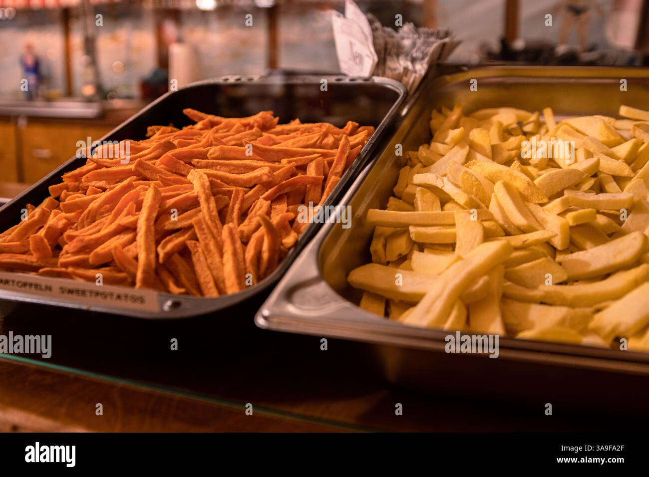To kinds of Yummy French fries in the metal trays. Potato chips on the ...