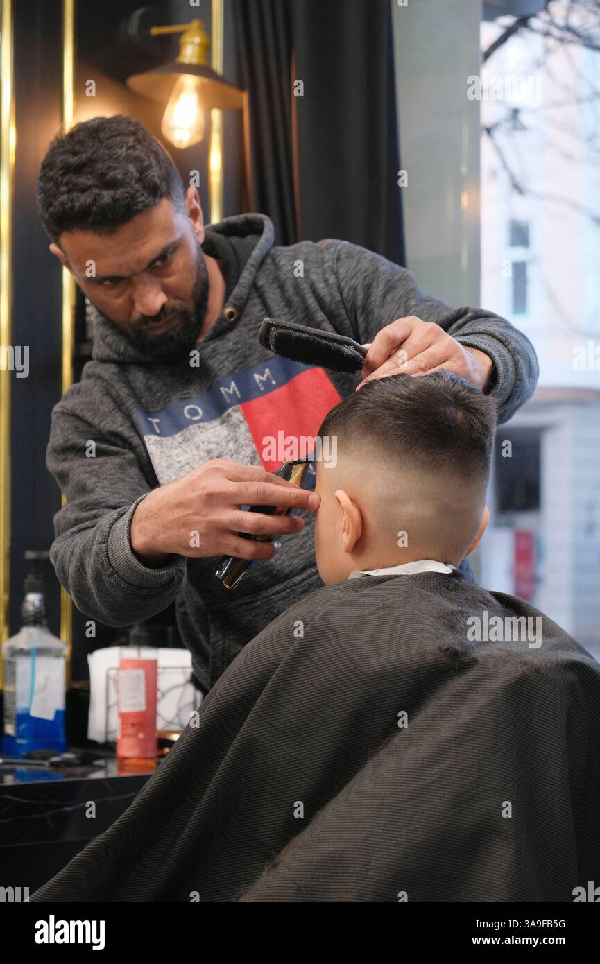 Bulgaria, Sofia; 9 March 2025, bulgarian kid having his hair cut in a local barber shop ...