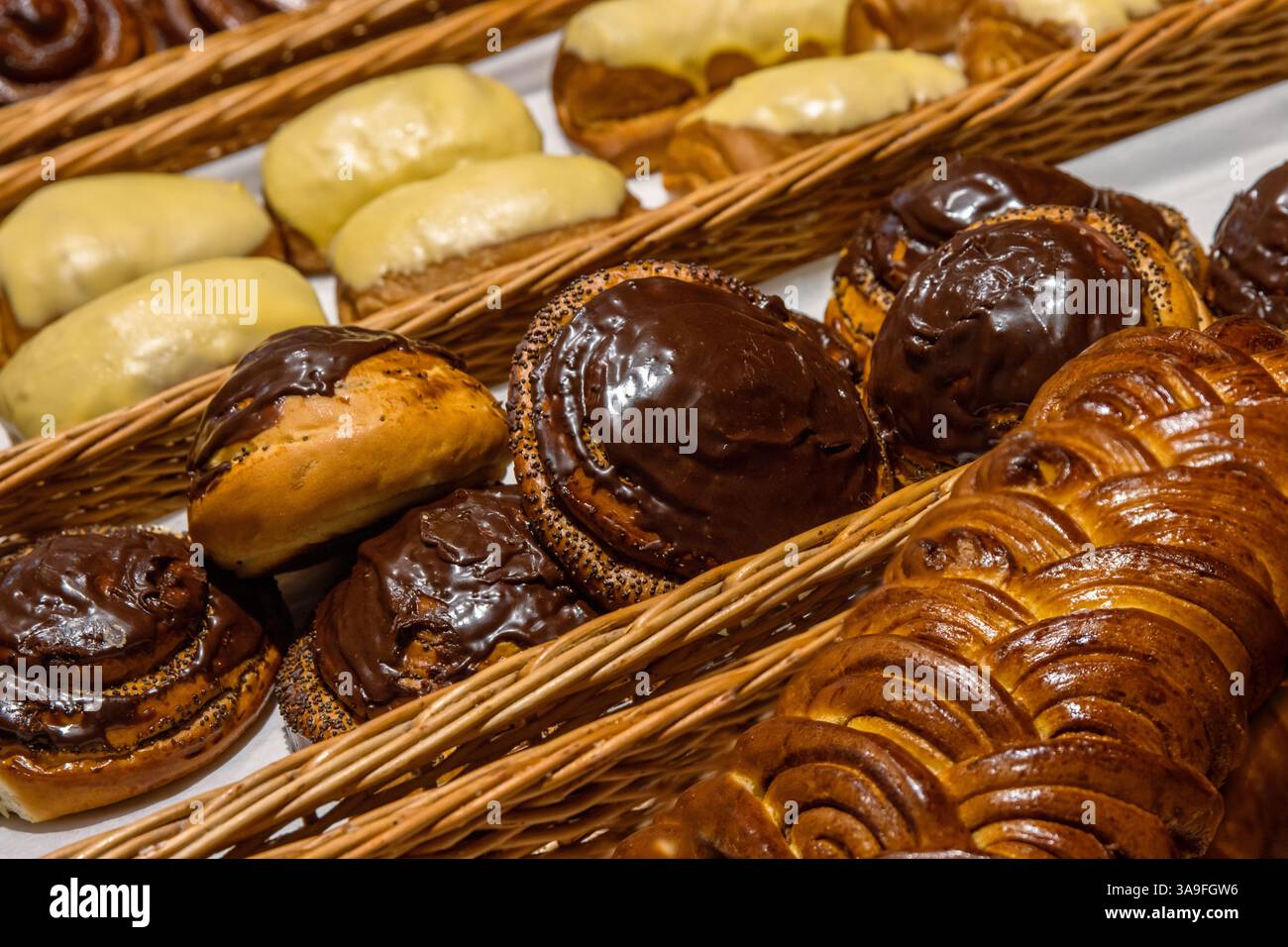A lot of sweet pastries in baskets on the counter in the food store ...