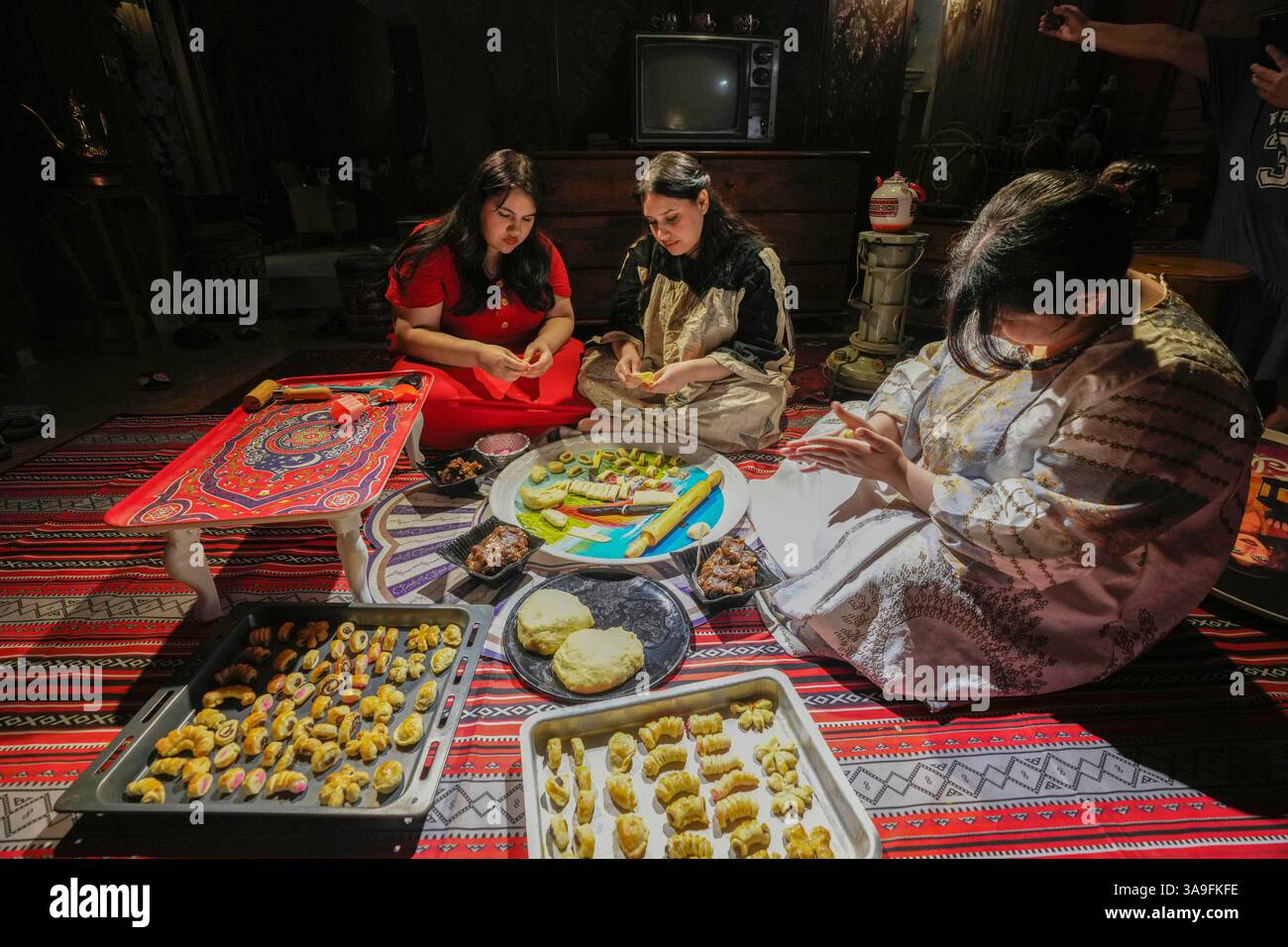 A family prepares cookies for the Eid al-Fitr holiday in Basra, Iraq ...