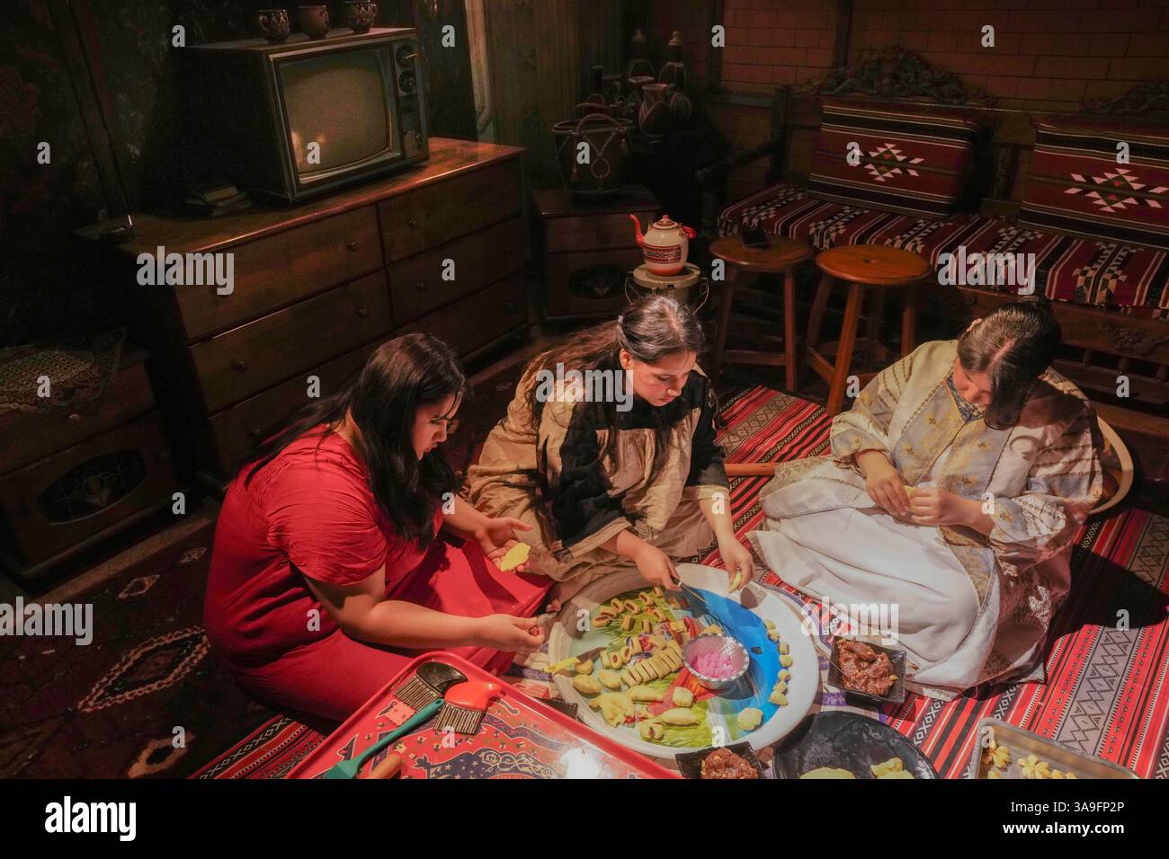 A family prepares cookies for the Eid al-Fitr holiday in Basra, Iraq ...