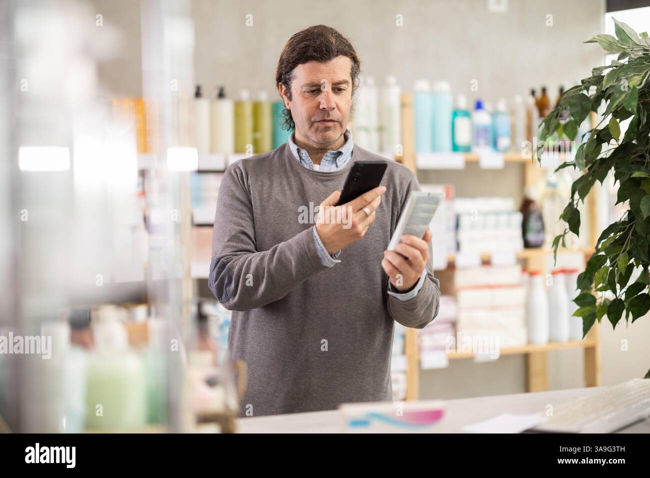 Man in pharmacy scans QR code on emollient cream product Stock Photo ...