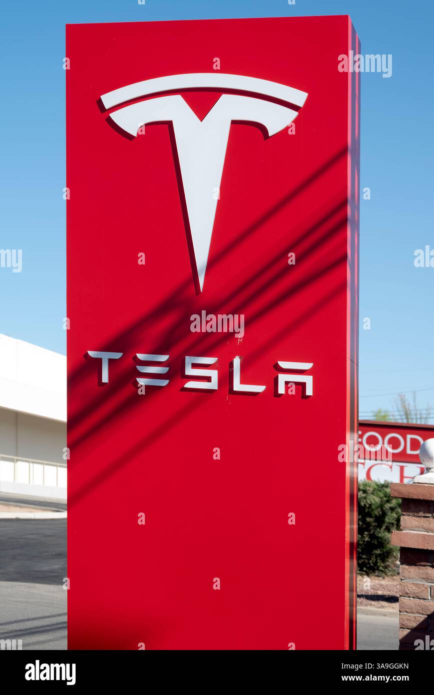Tesla Dealership with logo on modern building and Tesla cars parked in ...