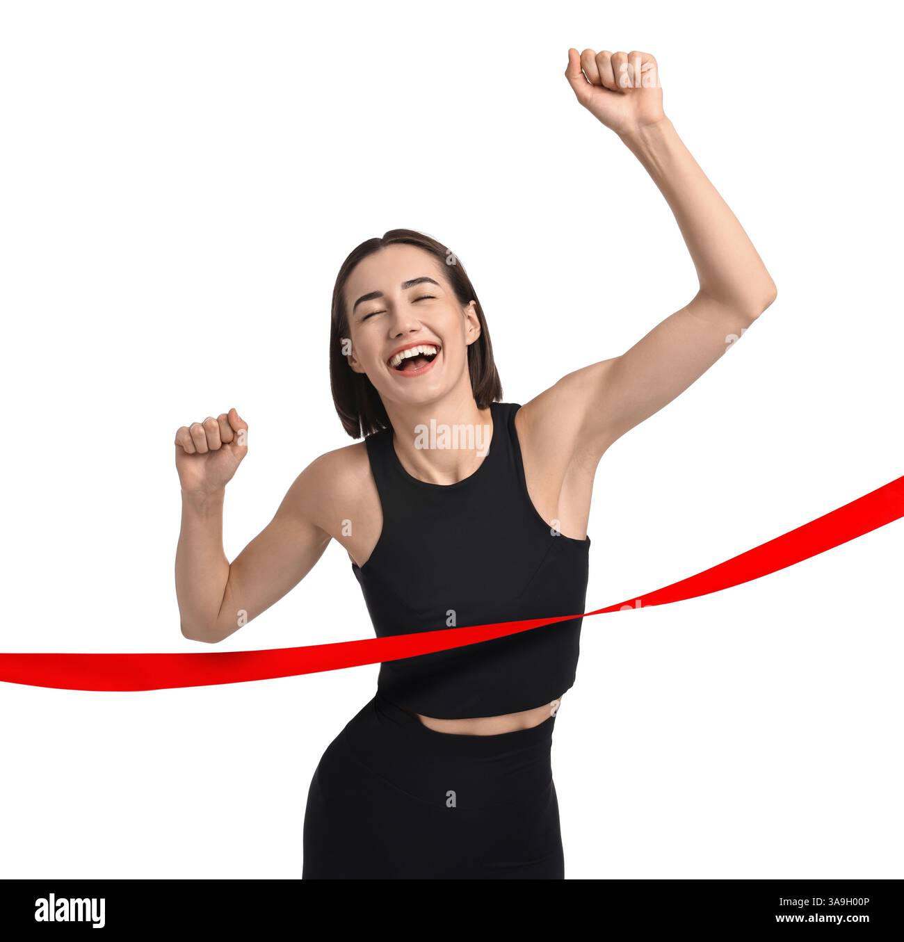 Happy sportswoman crossing red finish line ribbon on white background ...