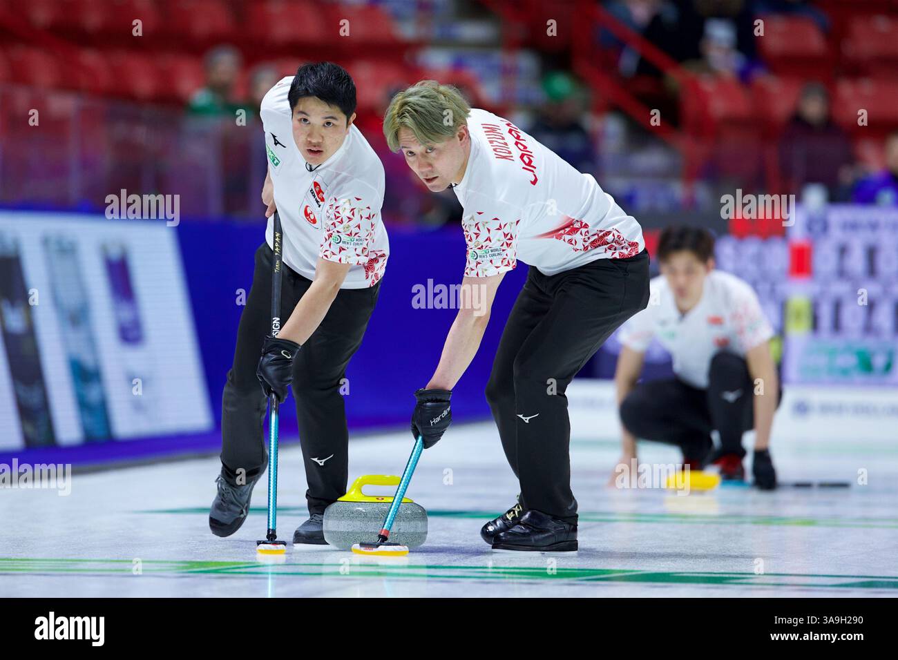 Usui Shingo (R) and Koizumi Satoshi (R) sweep a stone on day two of the 2025 World Men's Curling ...