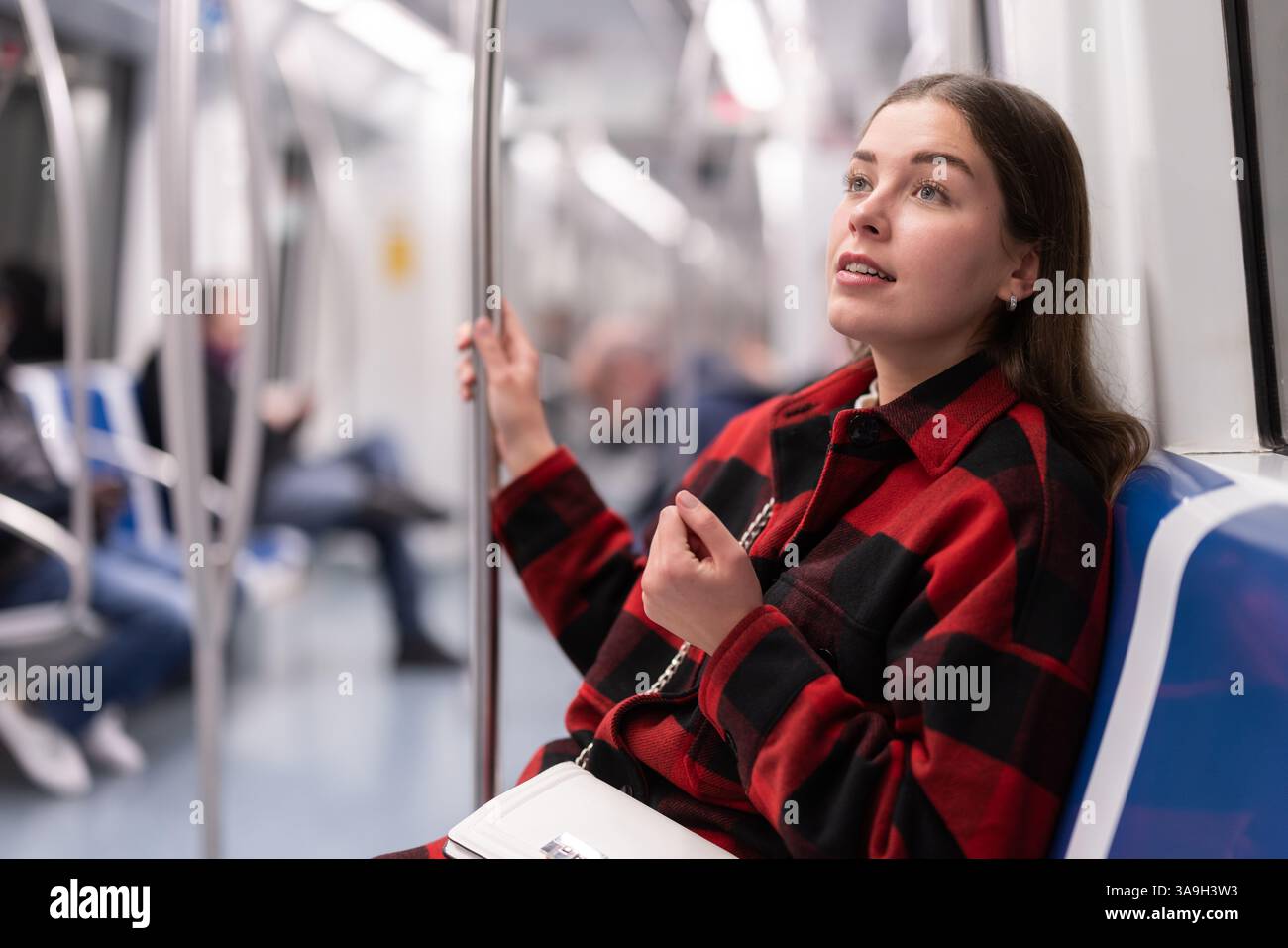 Girl sitting in subway and looking at map Stock Photo - Alamy