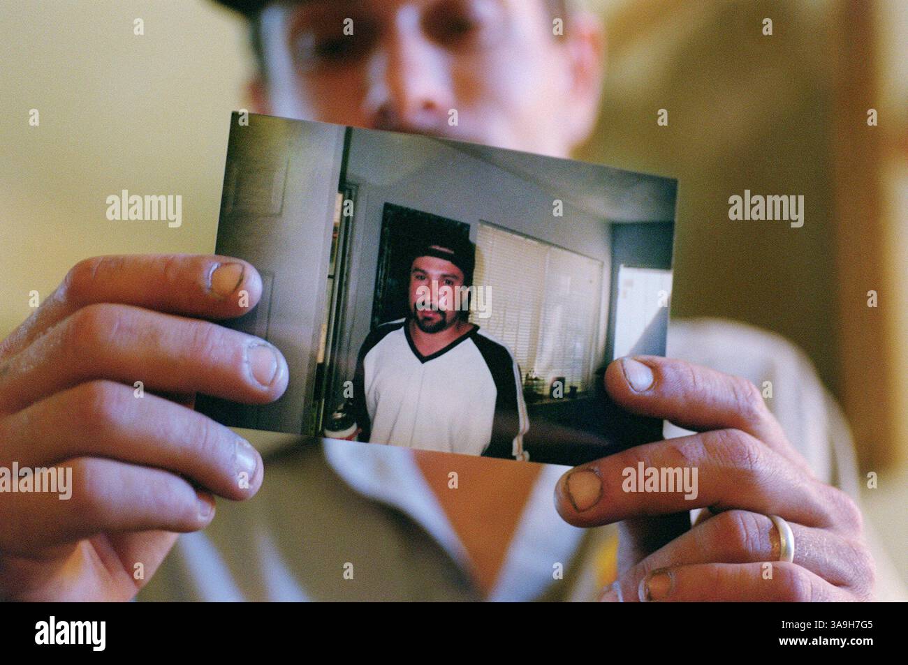 Brian Hite (cq) of Oak Park holds a family photo of his brother Darrell ...