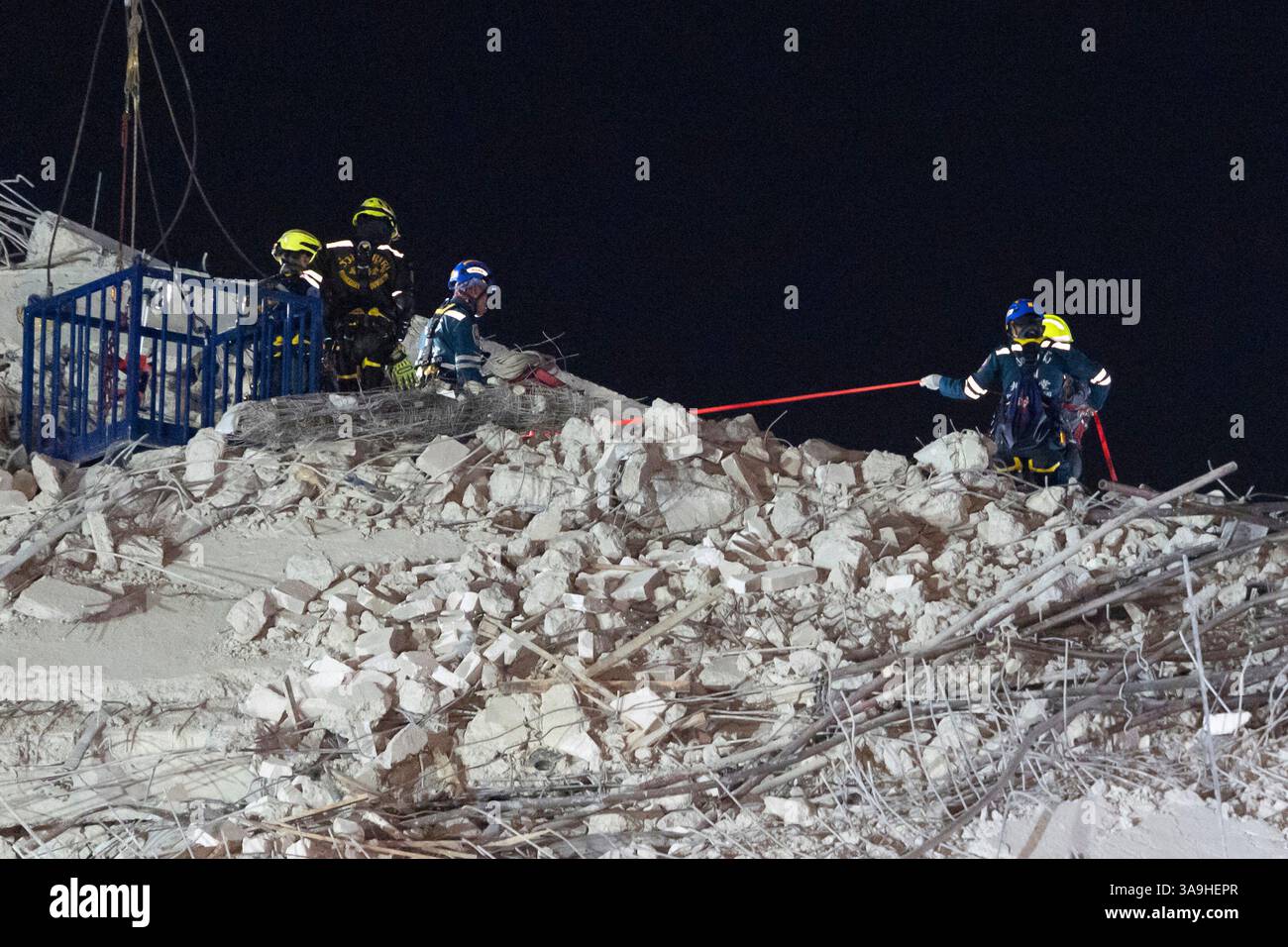 Rescuers work at the site of an under-construction high-rise building ...