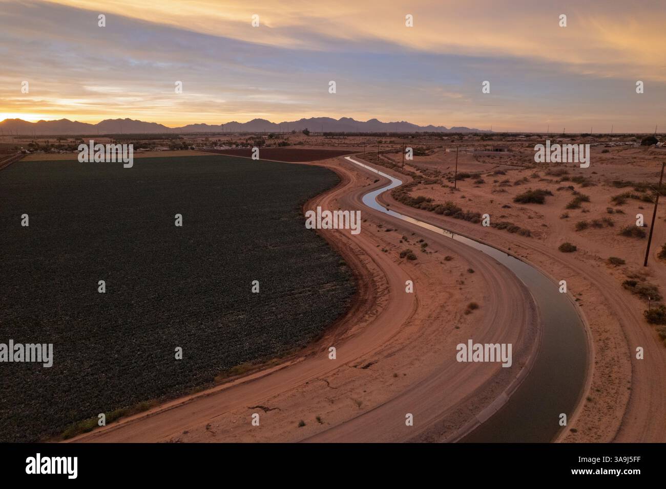 Aerial view of farmland and irrigation canal at sunrise near Yuma ...