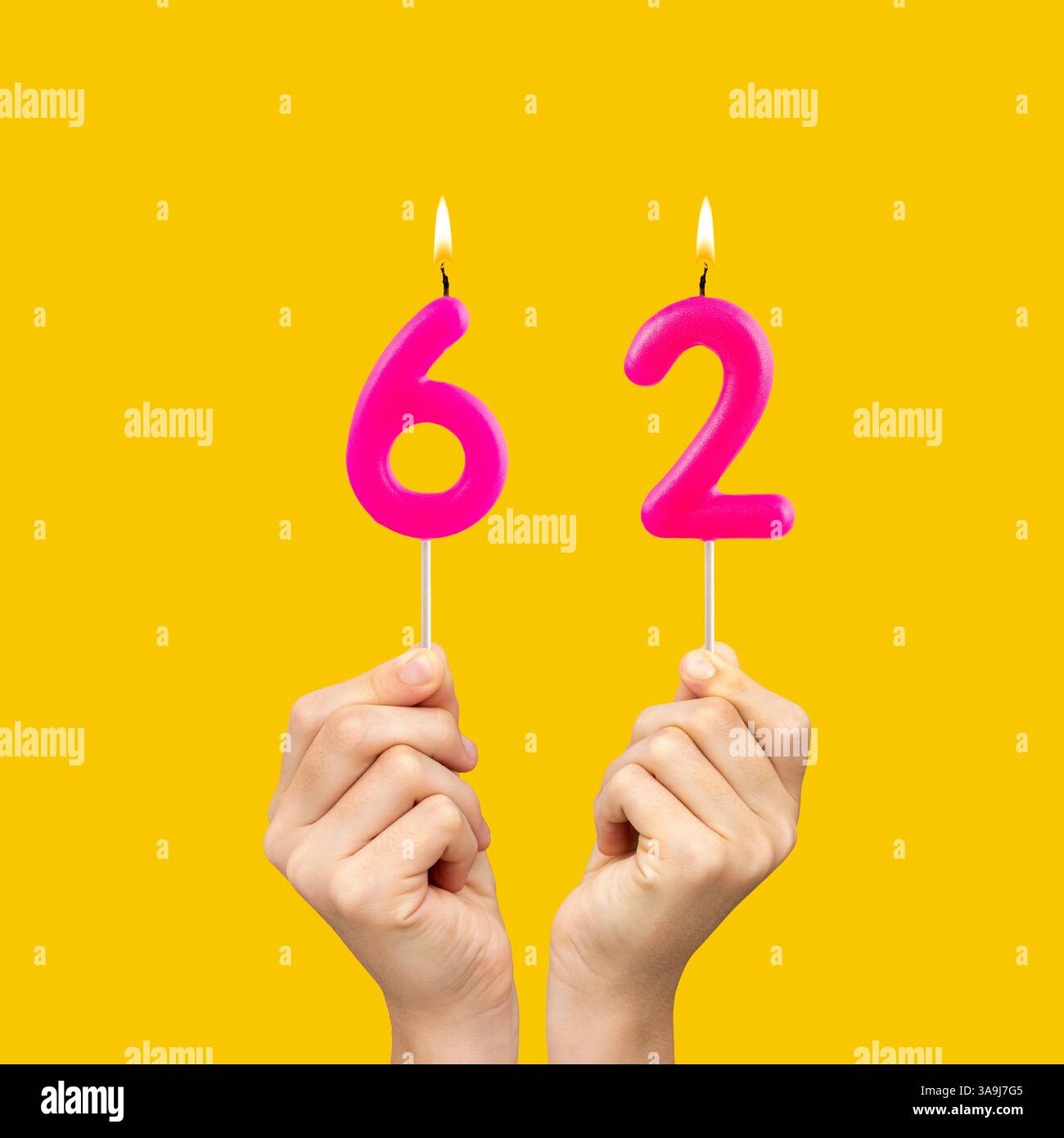 Hands holding birthday candles with number 62 - Yellow background Stock ...