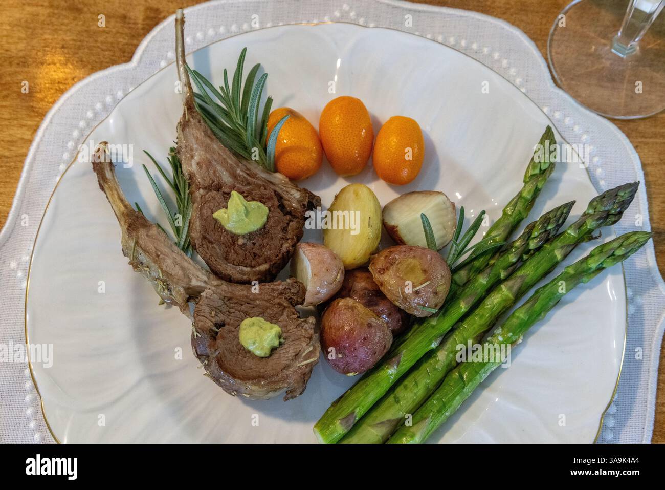 Plate of Roasted lamb with rosemary and kumquat garnish with potatoes ...