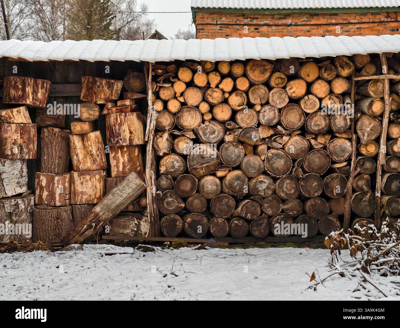 Stacked logs and winter's embrace in a peaceful rural setting near a ...