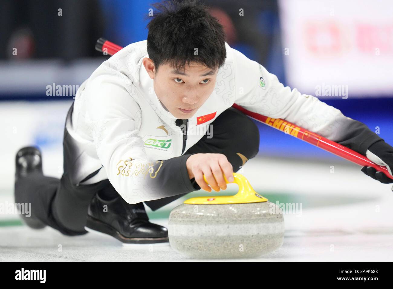 China's Xueqing Fei throws a stone during his country's session against ...