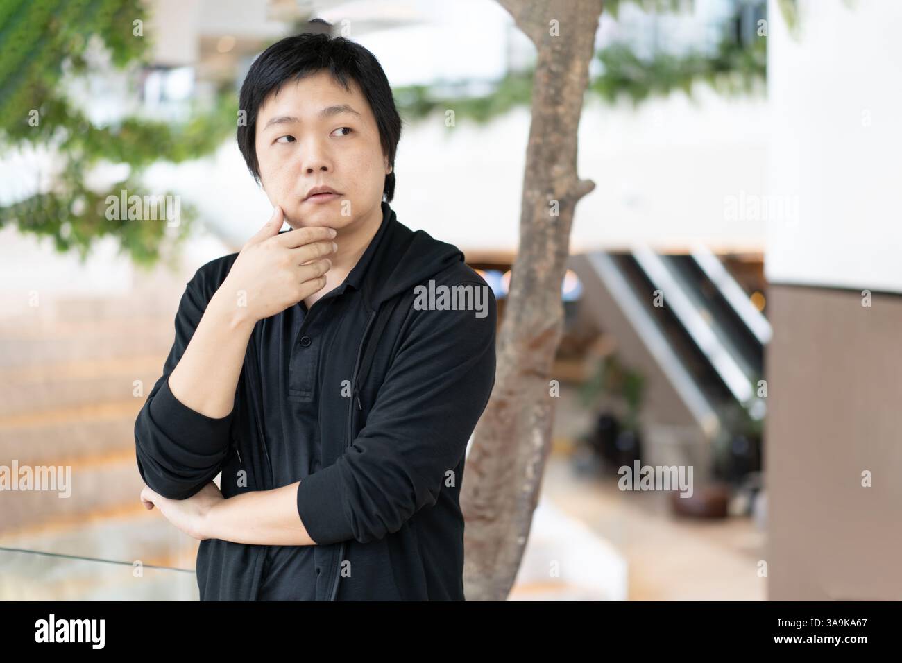 In a refined indoor environment, an Asian man in his middle age ...